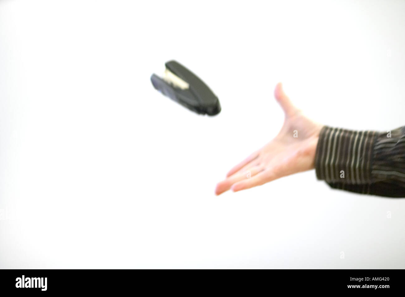 Mans hand catching falling office stapler Stock Photo - Alamy