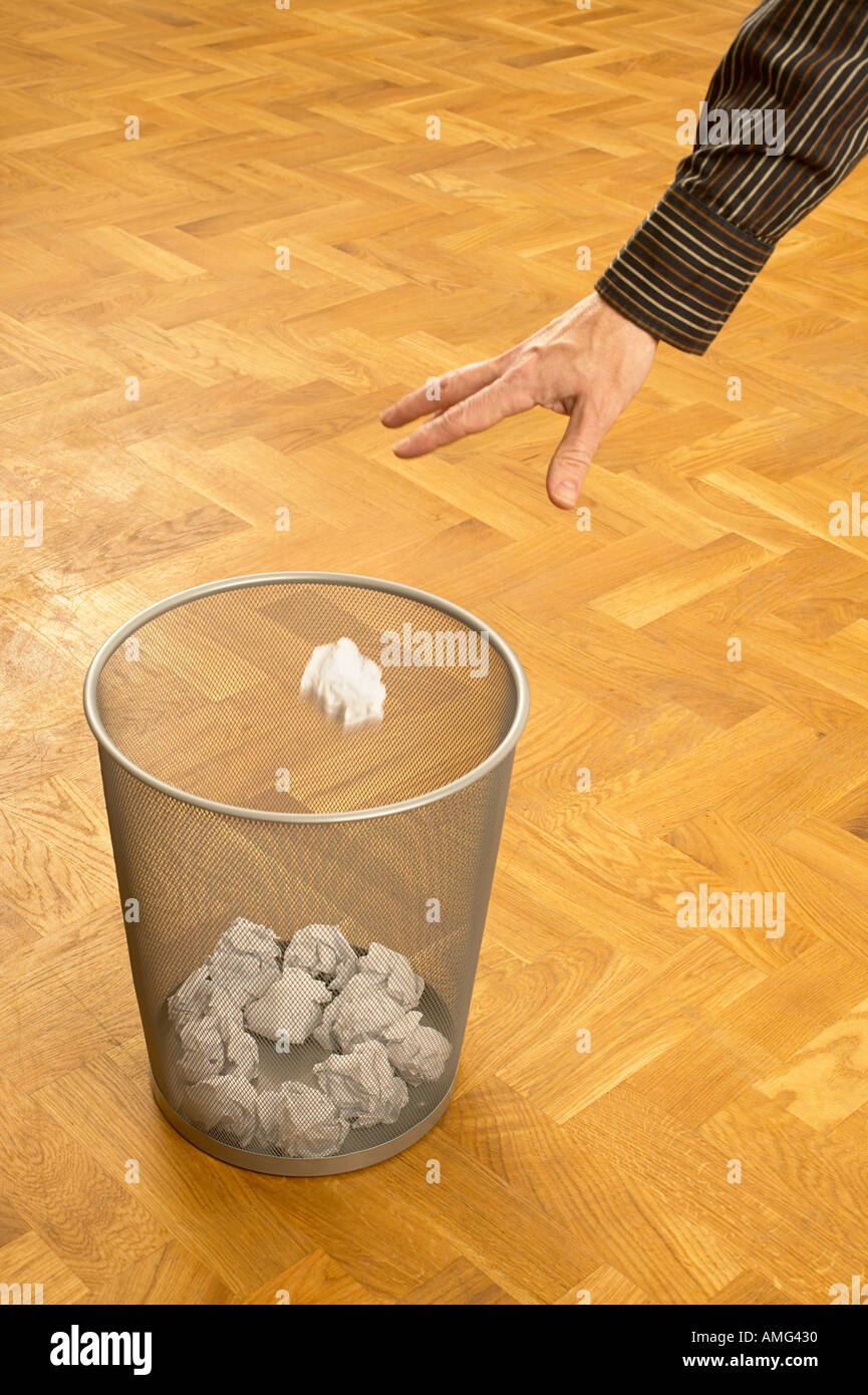 mans hand throwing scrunched up crunched ball of paper into a waste ...