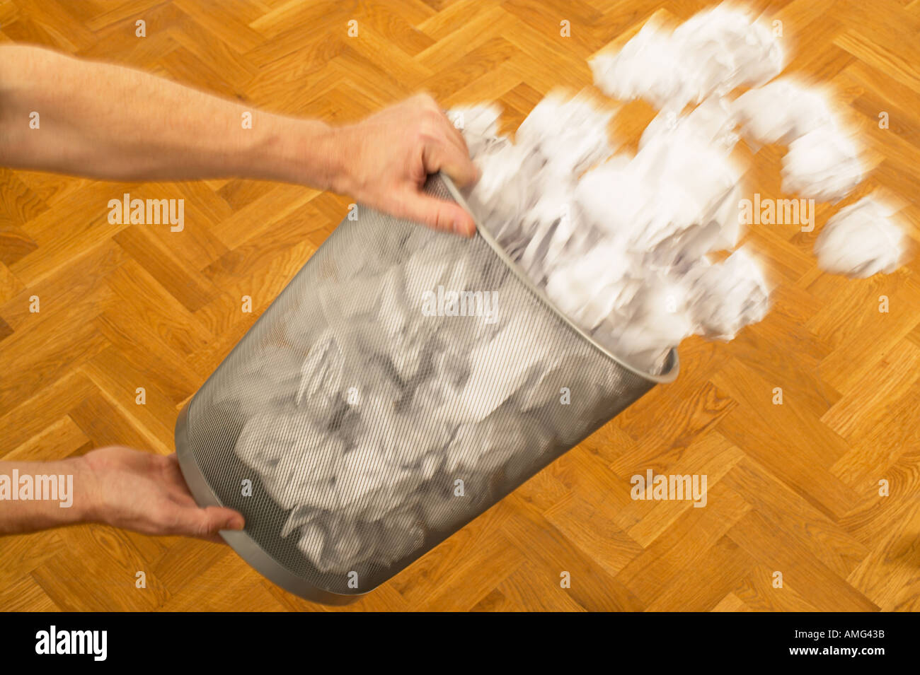 frustrated man throwing basket of waste paper across office in anger ...