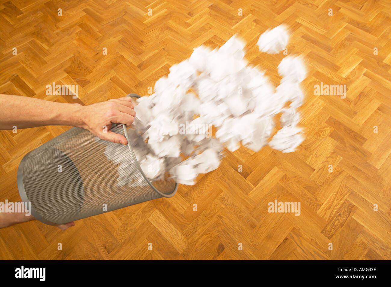 frustrated man throwing basket of waste paper across office in anger ...