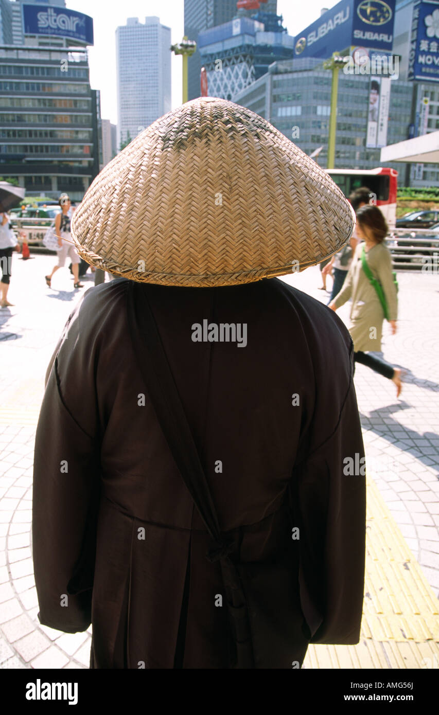 A Buddhist monk, seen from behind, outside Shinjuku Station in Tokyo ...