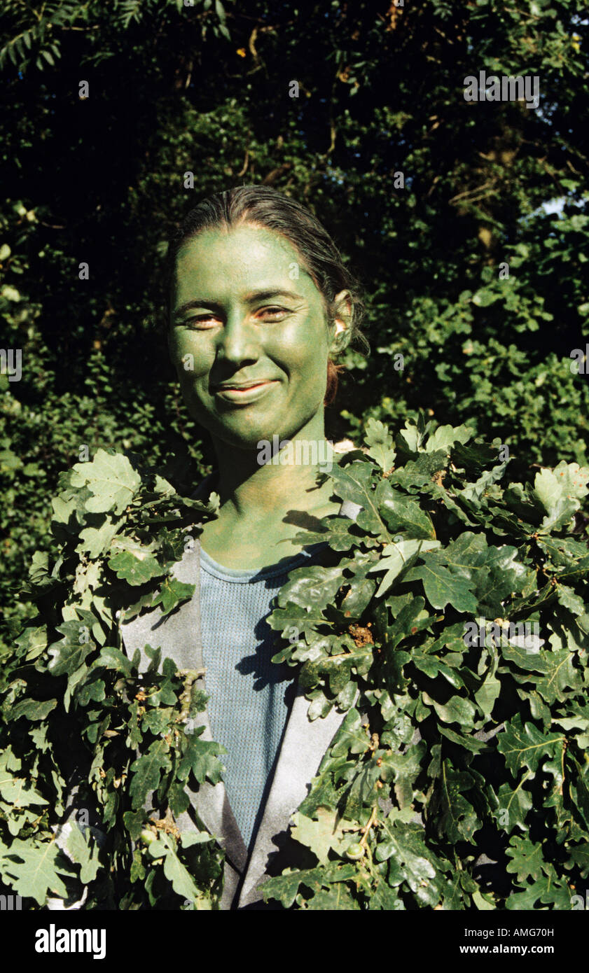 Lady whose face is painted green, wearing dress covered in foliage for ...