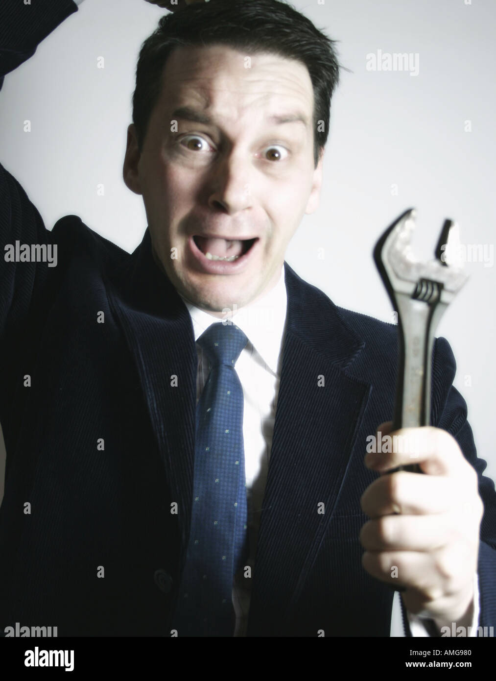 Business man shows panic at the sign of a spanner Stock Photo - Alamy