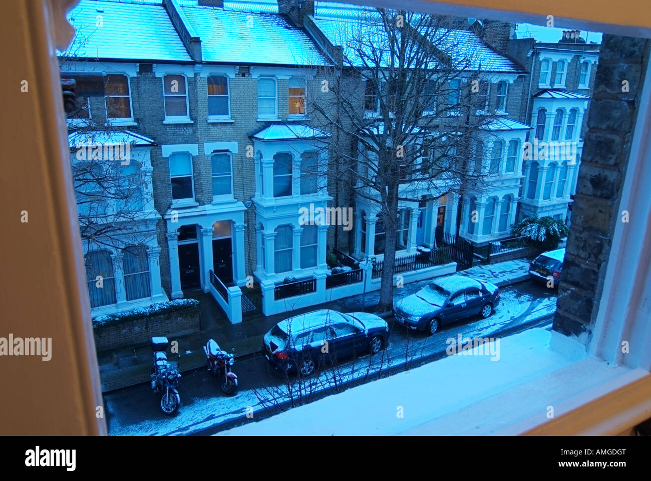 Snowy street scene viewed from a window in London in winter showing ...