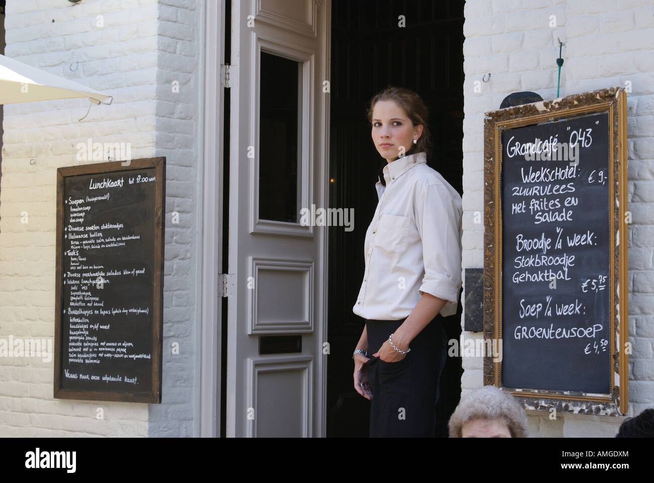 Young waitress waiting for custom by the door of Maastricht restaurant ...