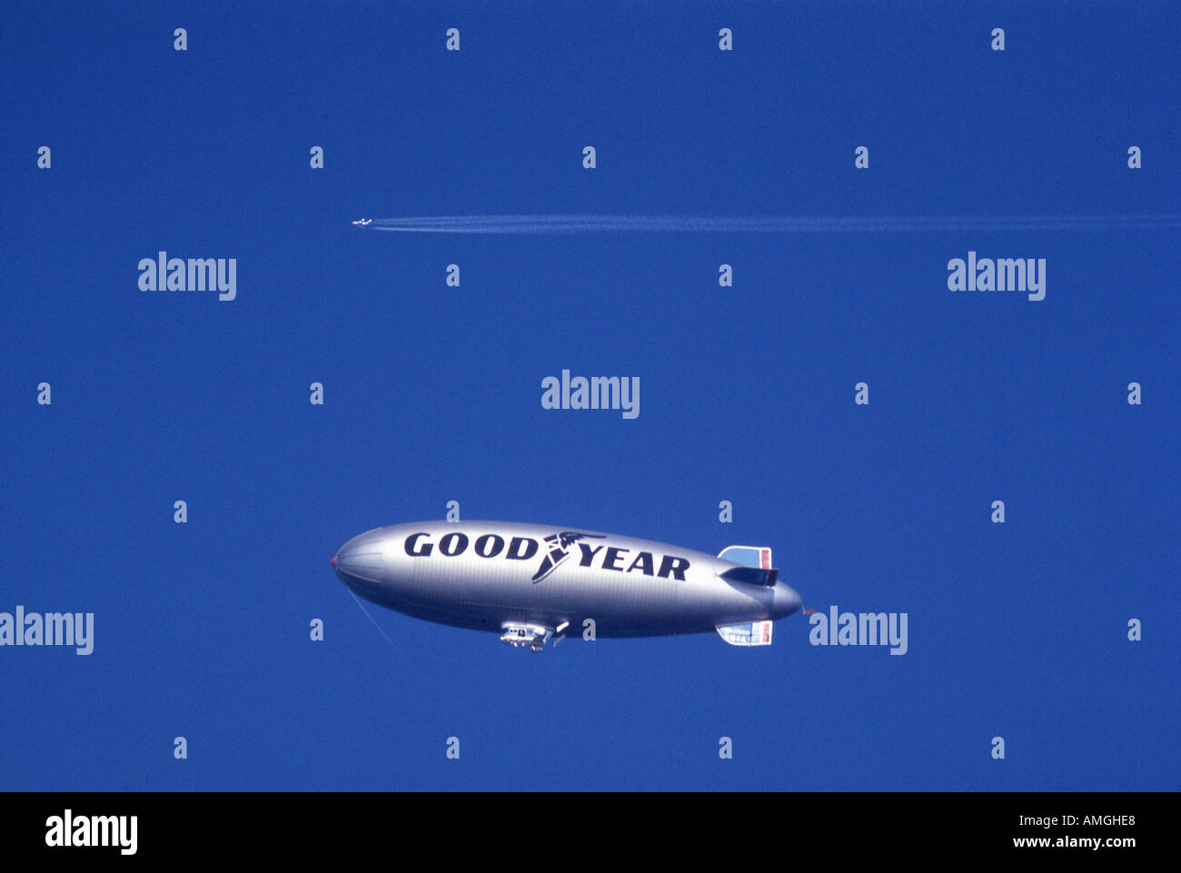 Goodyear blimp Columbia and jet airplane with vapor trails over ...