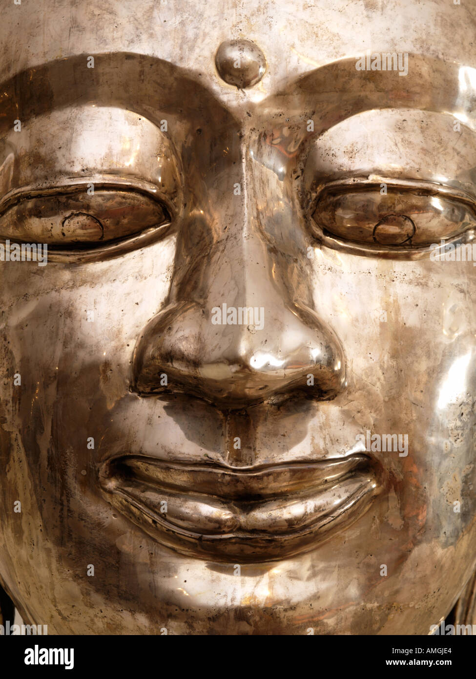 Closeup of shiny metal hindu indian god deity head face smile ...