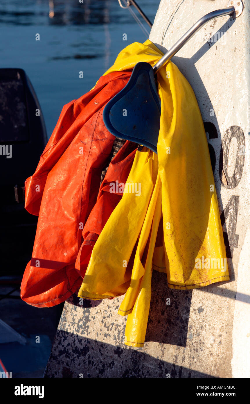 Vertical close up of orange and yellow fisherman’s waterproof oilskin ...