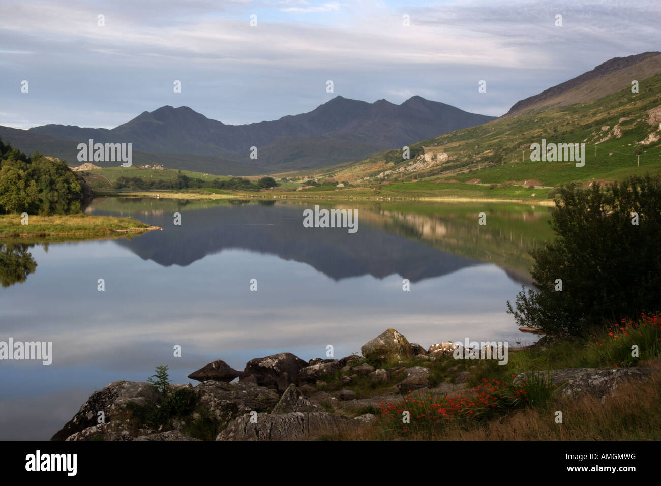 The summit of Snowdon is reflected in the lake at Capel Curig ...