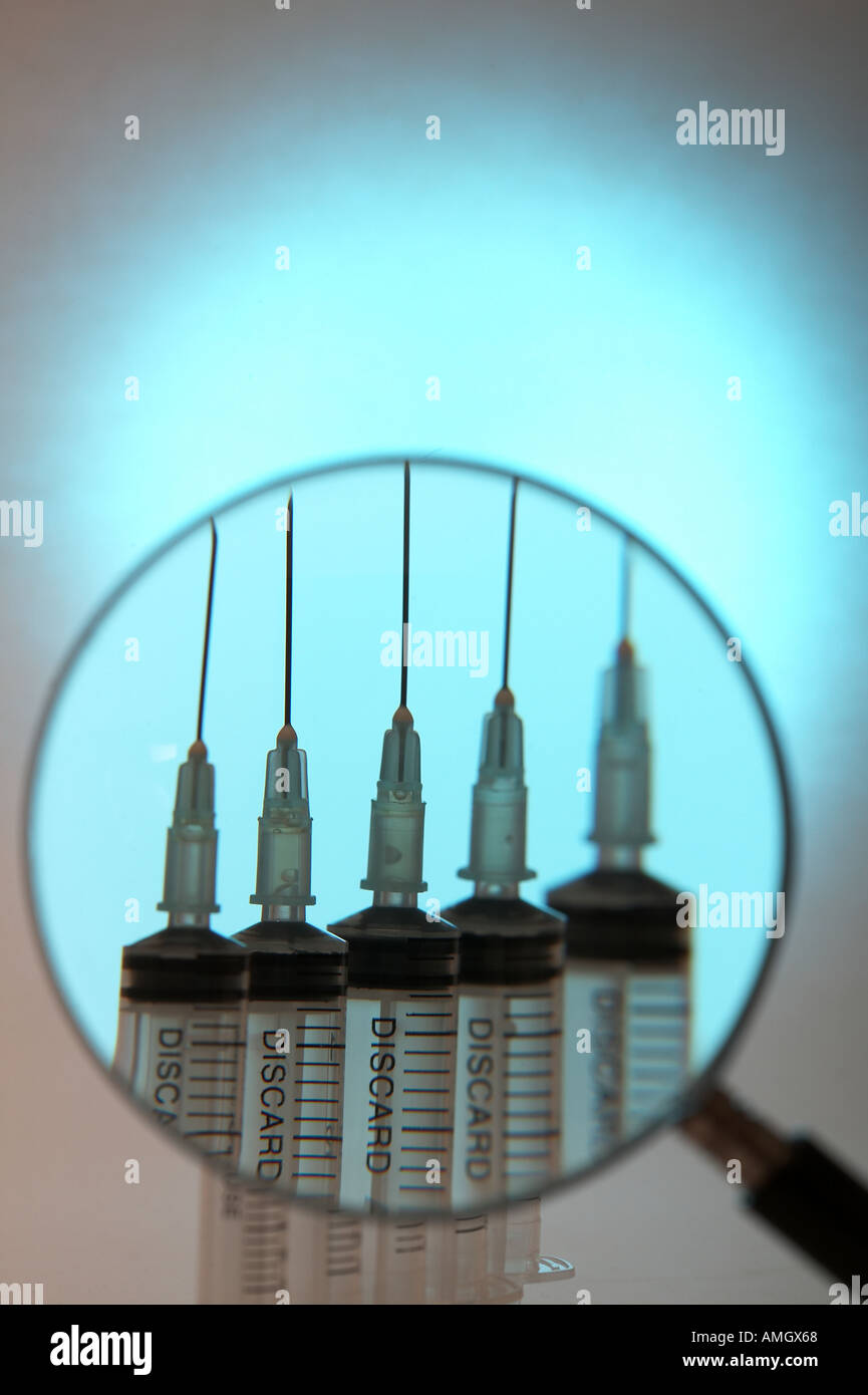 Needles with magnifying glass Stock Photo - Alamy