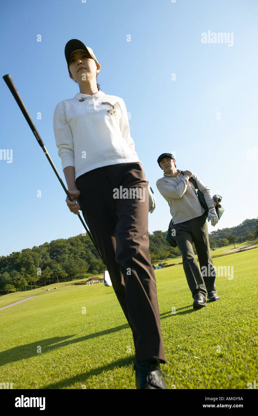 Two people walking in the golf course Stock Photo - Alamy
