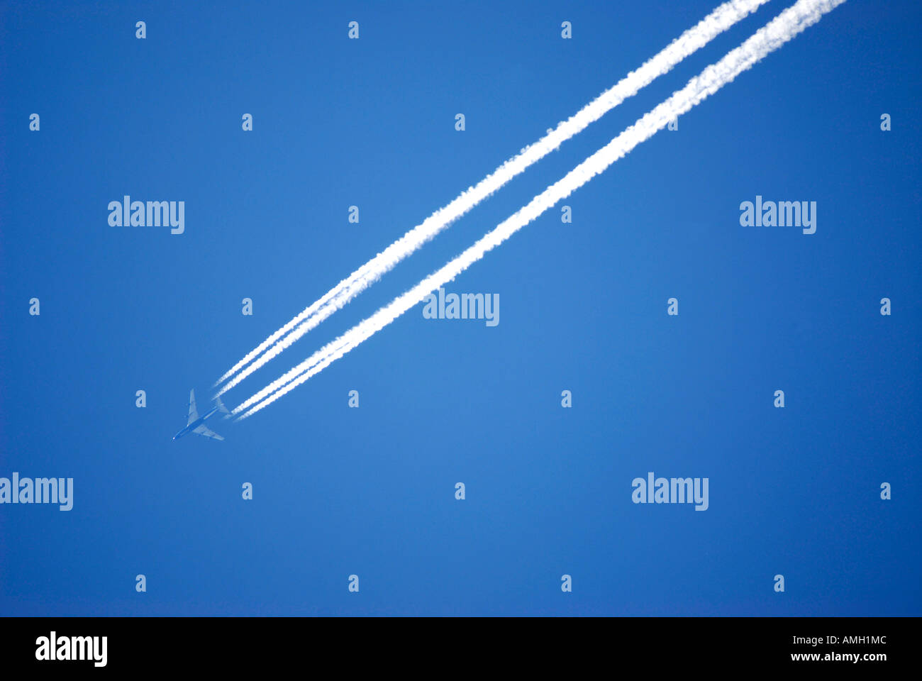 Contrail of a jet aircraft flying high in a blue sky Stock Photo - Alamy