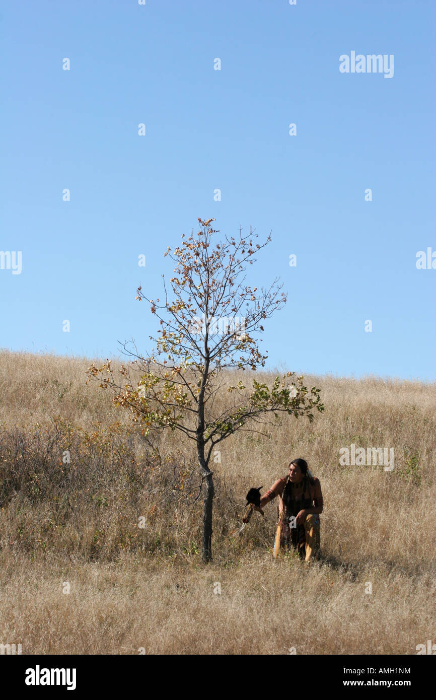 A Native American Indian man crouching in the dead grasses hunting game ...