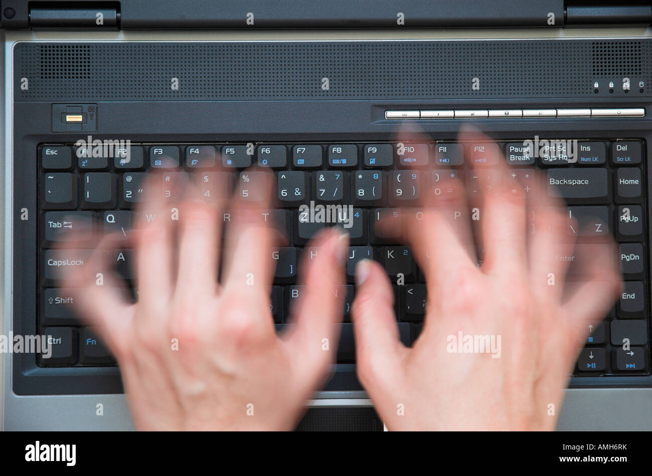 Woman typing on computer keyboard blurred motion Stock Photo - Alamy