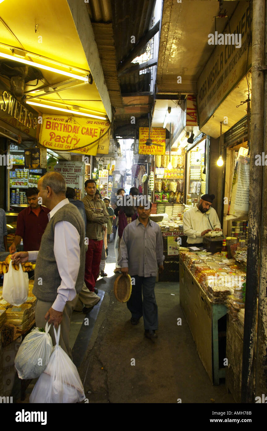 An alley way in INA market, New Delhi, with stores selling sweets and ...