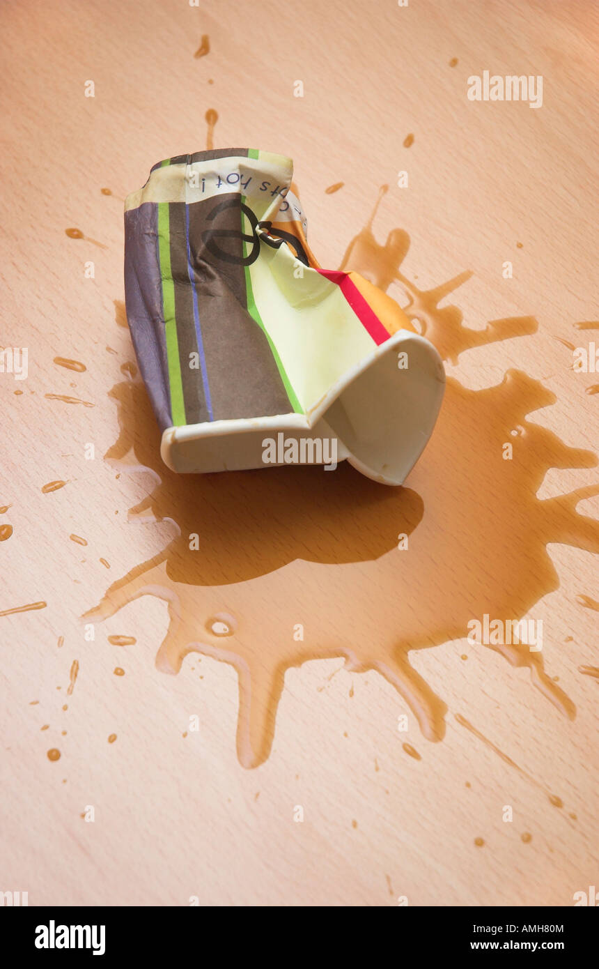 Crushed coffee cup and spilt coffee on office desk Stock Photo - Alamy