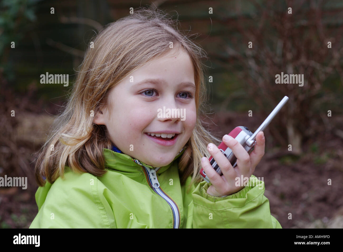 Young girl using a walkie talkie radio transmitter to talk to friends ...