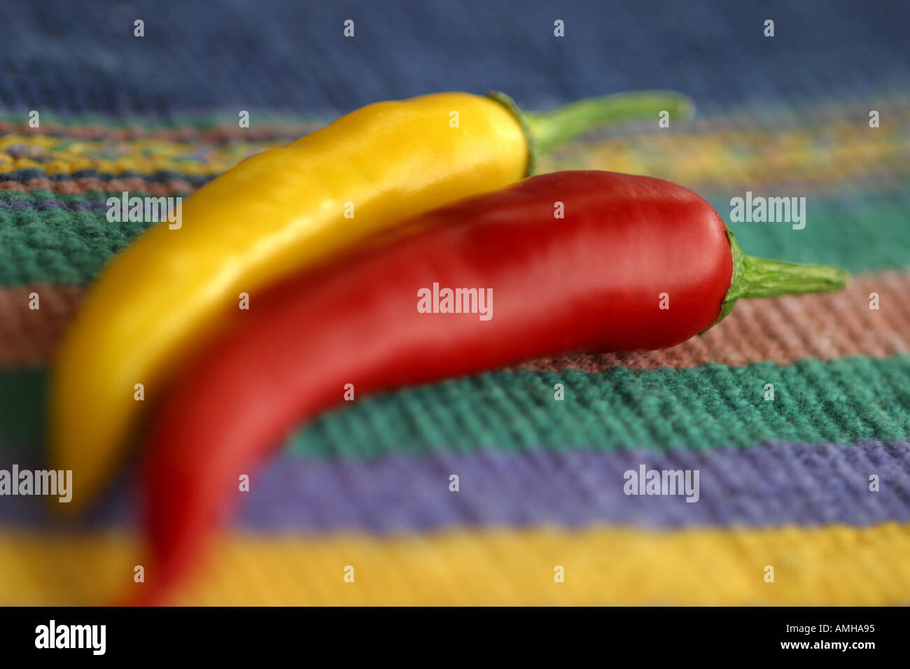 Yellow and red chile peppers on a colorful cloth Stock Photo - Alamy
