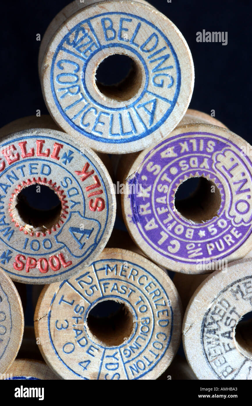 A pile of empty sewing thread spools against black background Stock ...