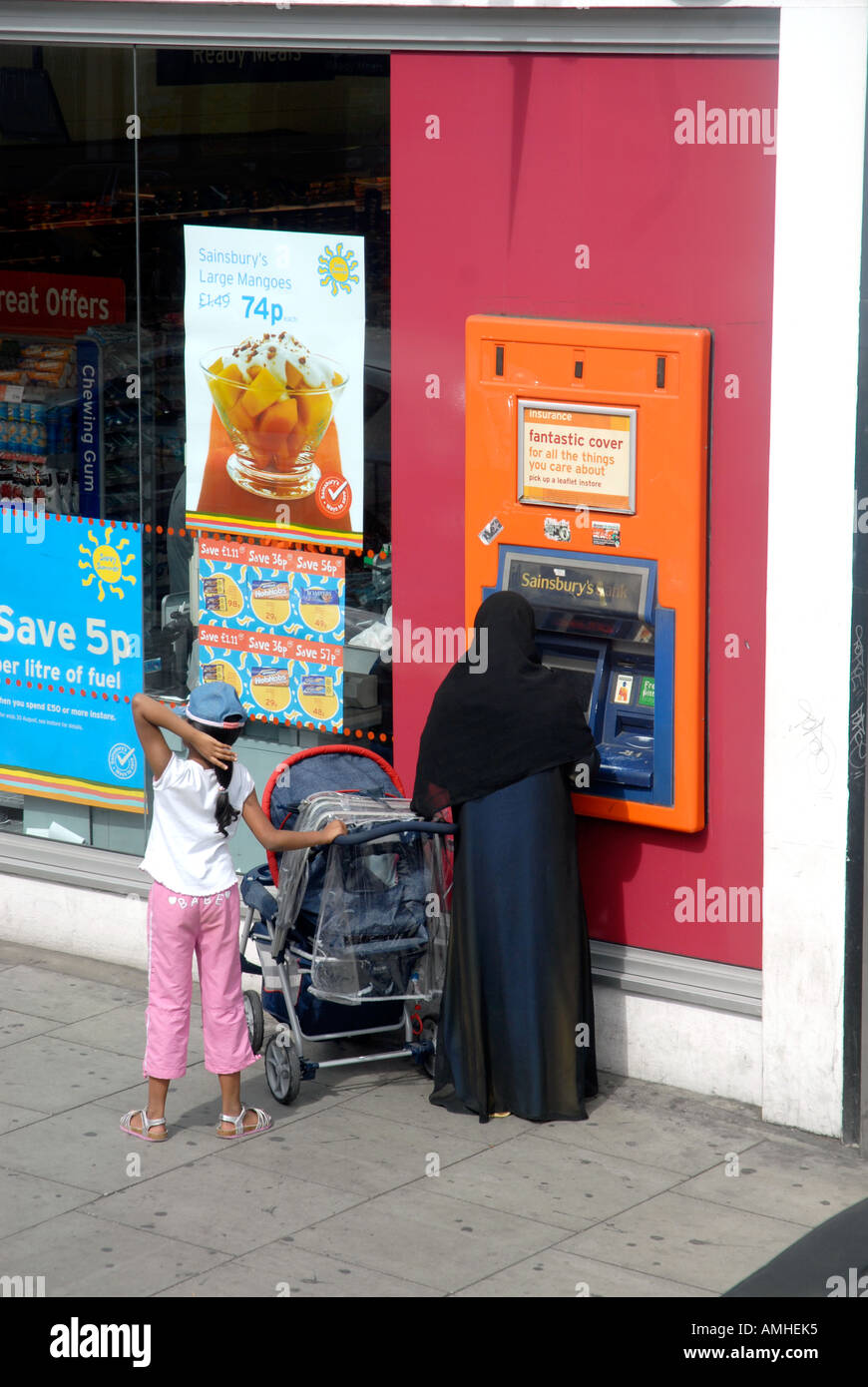 Muslim woman at a cashpoint ATM machine in Camden Town London Stock ...