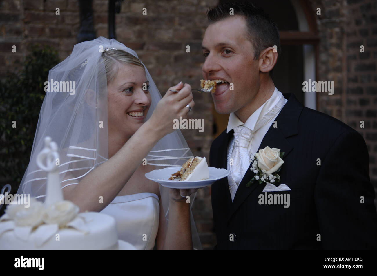 Bride feeding the groom with the wedding cake Stock Photo - Alamy