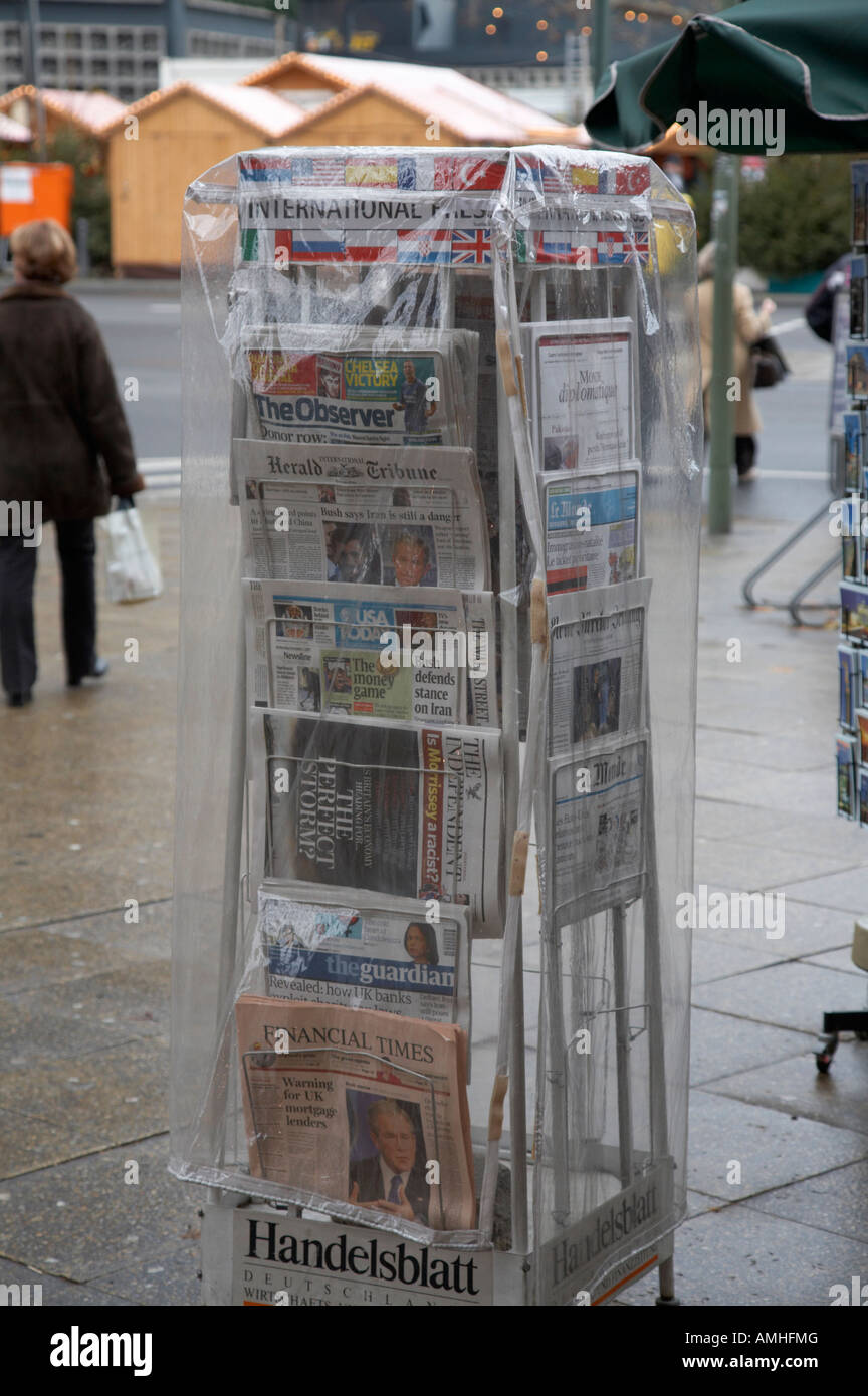 newspapers on an outdoor news stand under plastic to protect from the ...