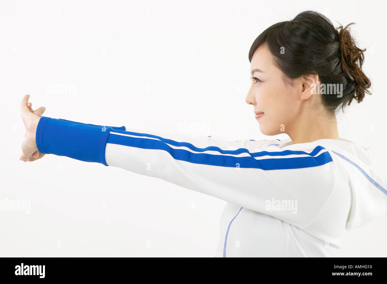 A woman in white gym suit stretching her arm Stock Photo - Alamy