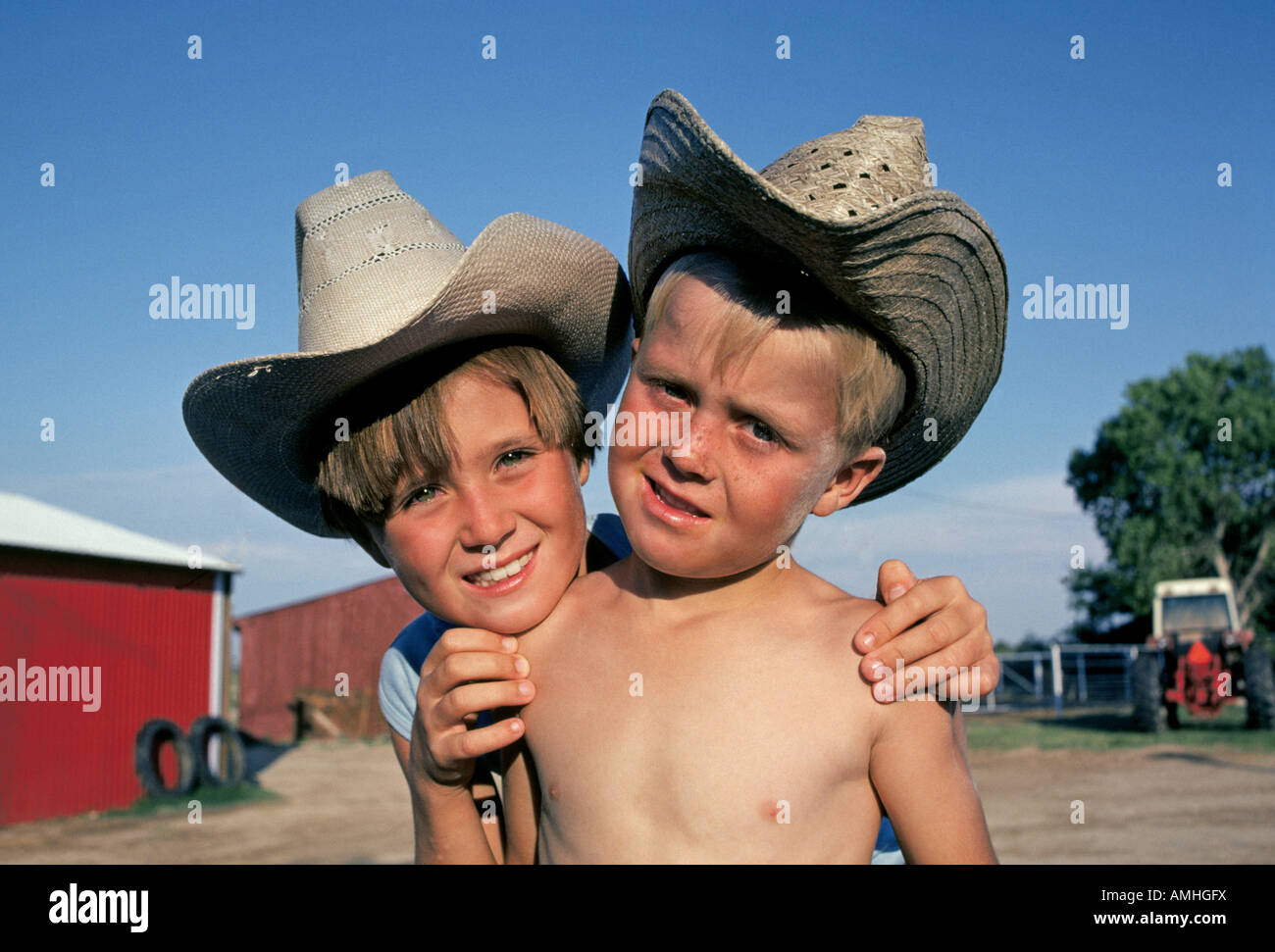 Two young ranch children with cowboy hats and brother and sister on ...
