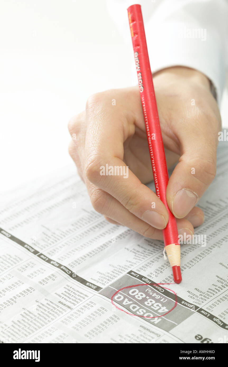 A man marking on the newspaper using a red pen Stock Photo - Alamy