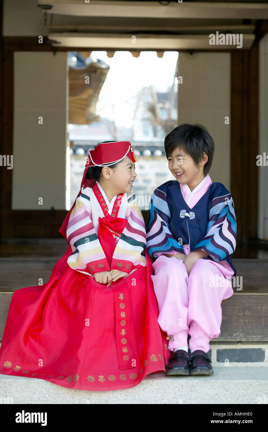 Children in Hanbok sit on the steps to the entrance hall Stock Photo ...