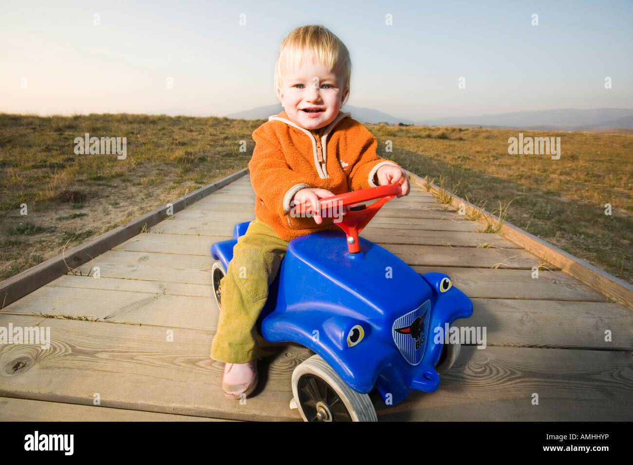 child driving toy car on wood path Stock Photo - Alamy