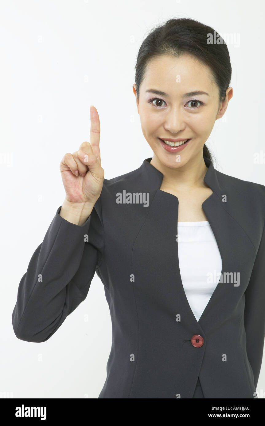A woman in formal suit holding her index finger up Stock Photo - Alamy