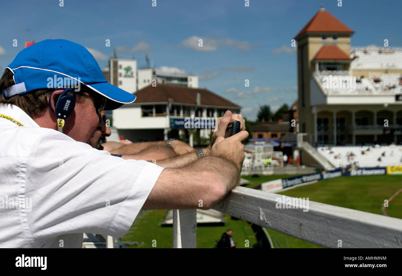 man taking photograph of Test Cricket Match using a mobile phone camera ...