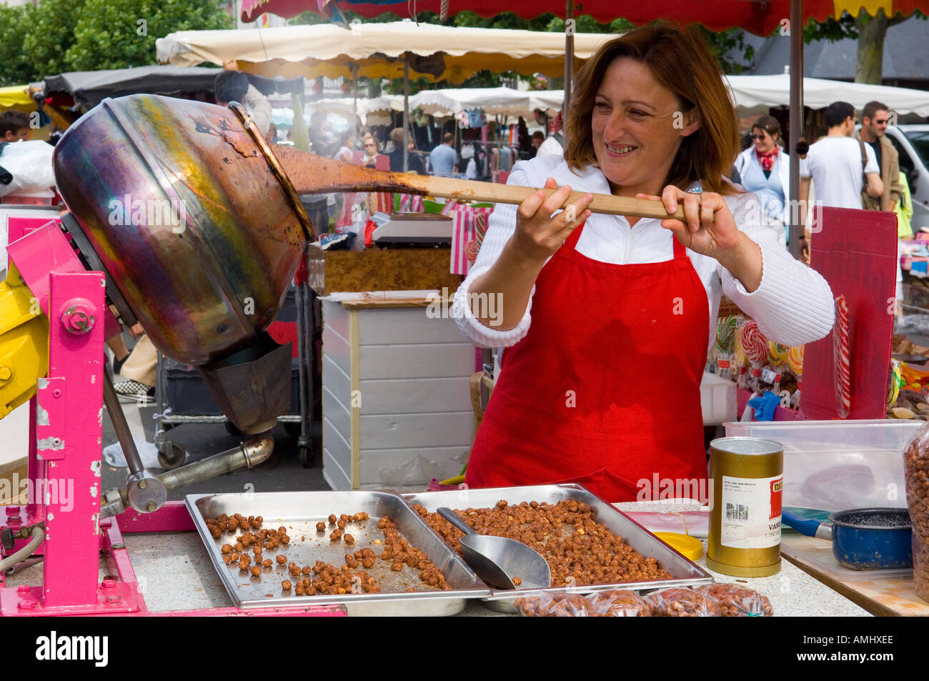 Woman coating nuts in chocolate at a stall in Trouville market in ...