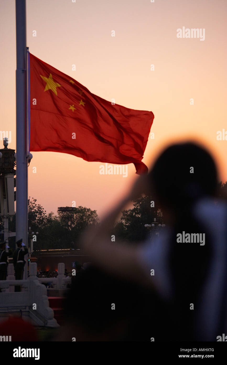 Tourist photographing the lowering of the flag Tiananmen Square Beijing ...