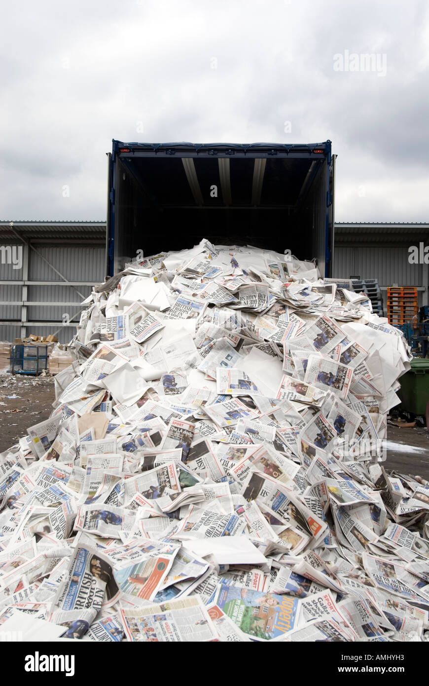 Lorry unloading pile of returned newspapers to paper recycling facility ...