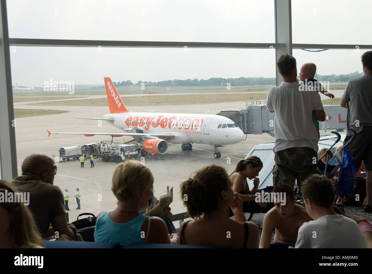 Passengers waiting at the departure gate to board an EasyJet plane at ...