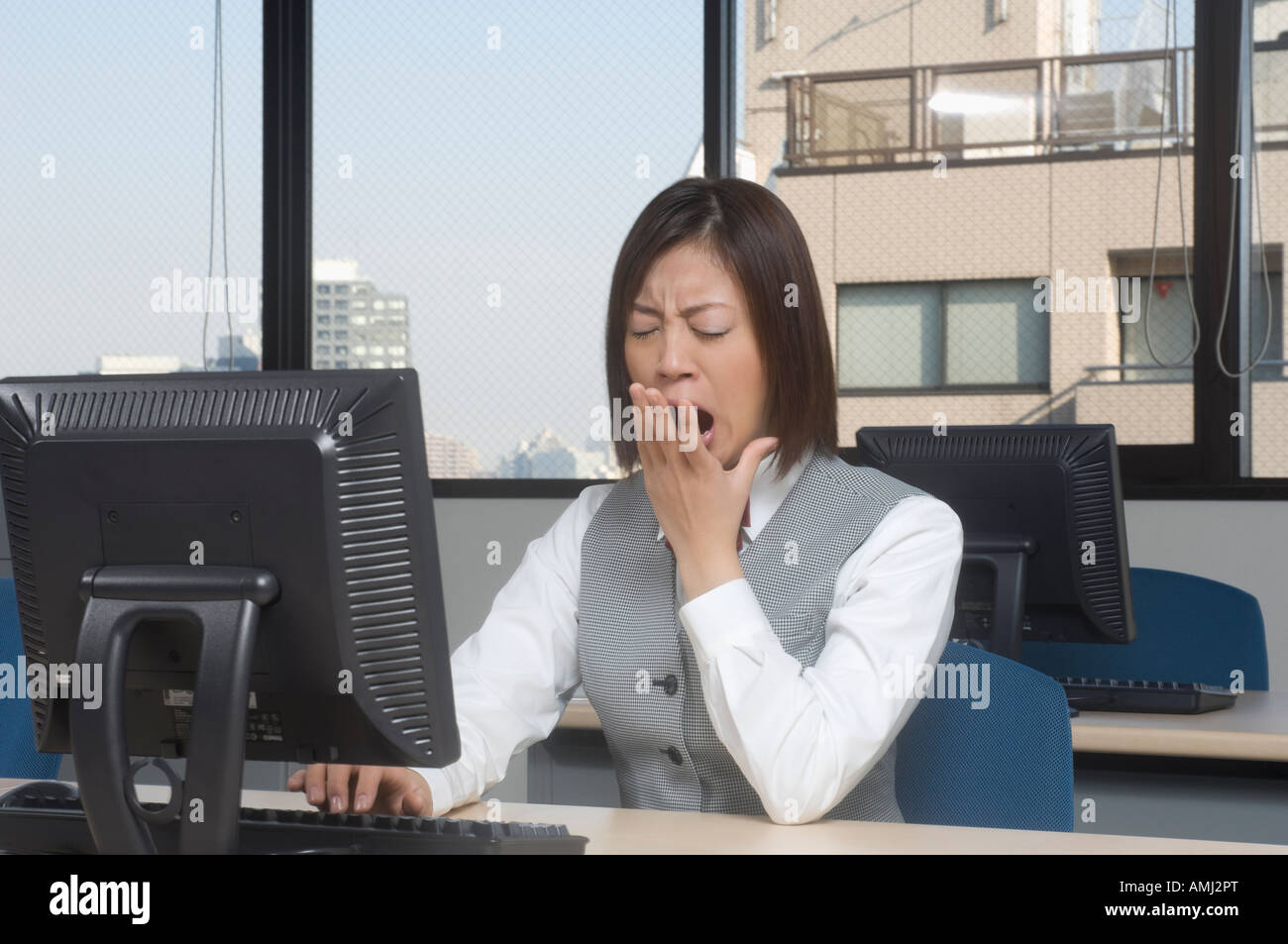 Office worker yawning Stock Photo - Alamy