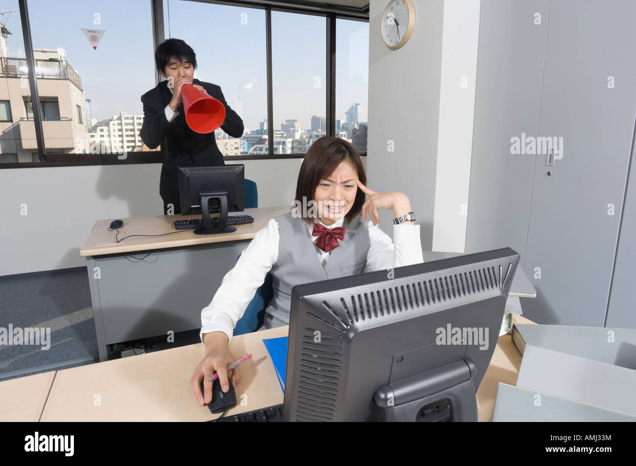 Office worker working on computer, manager yelling from behind Stock ...