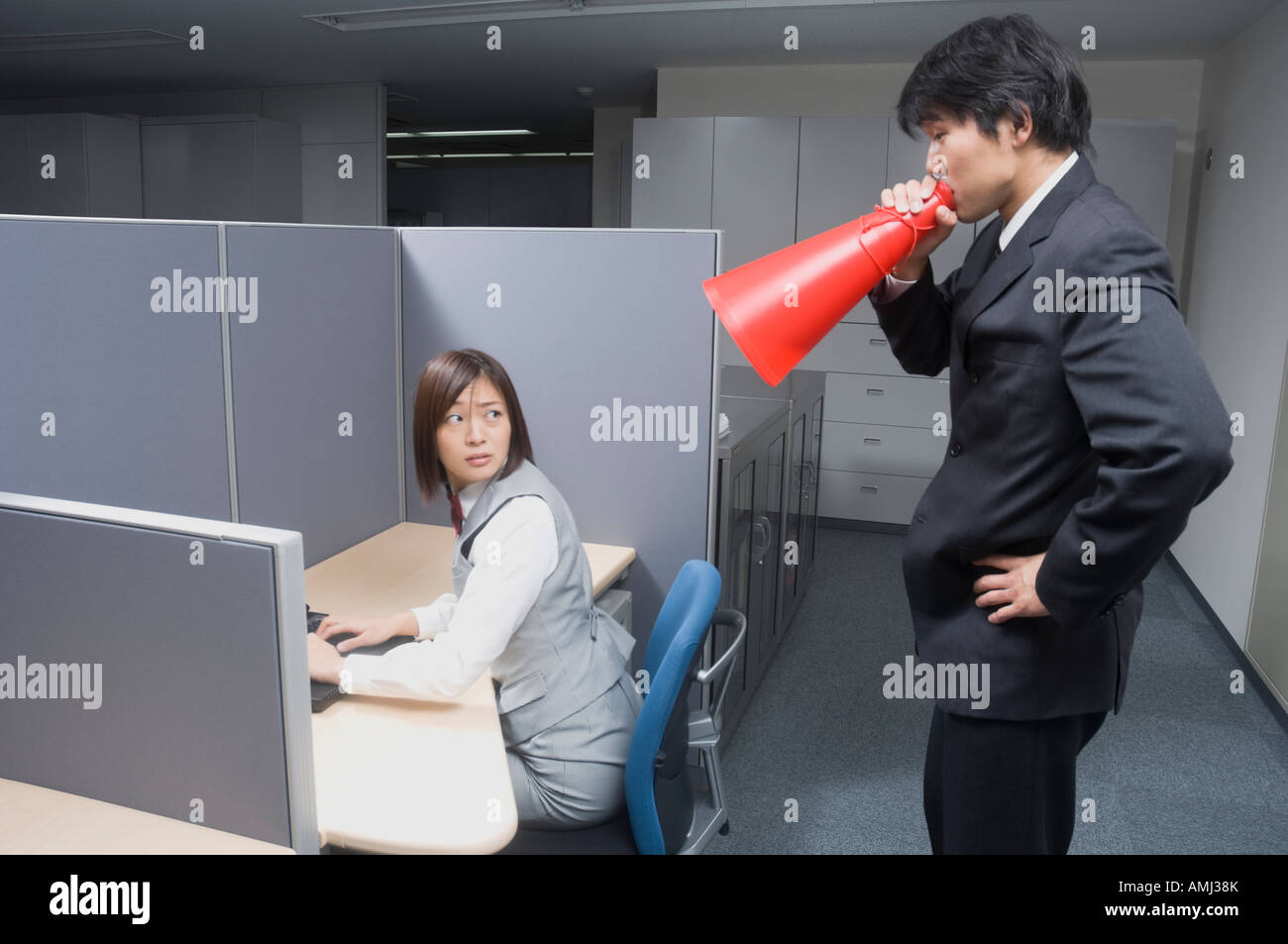 Businessman talking to office worker using megaphone Stock Photo - Alamy
