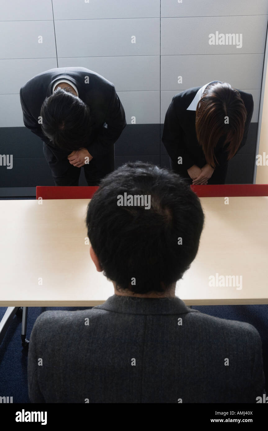 Two business people bowing Stock Photo - Alamy