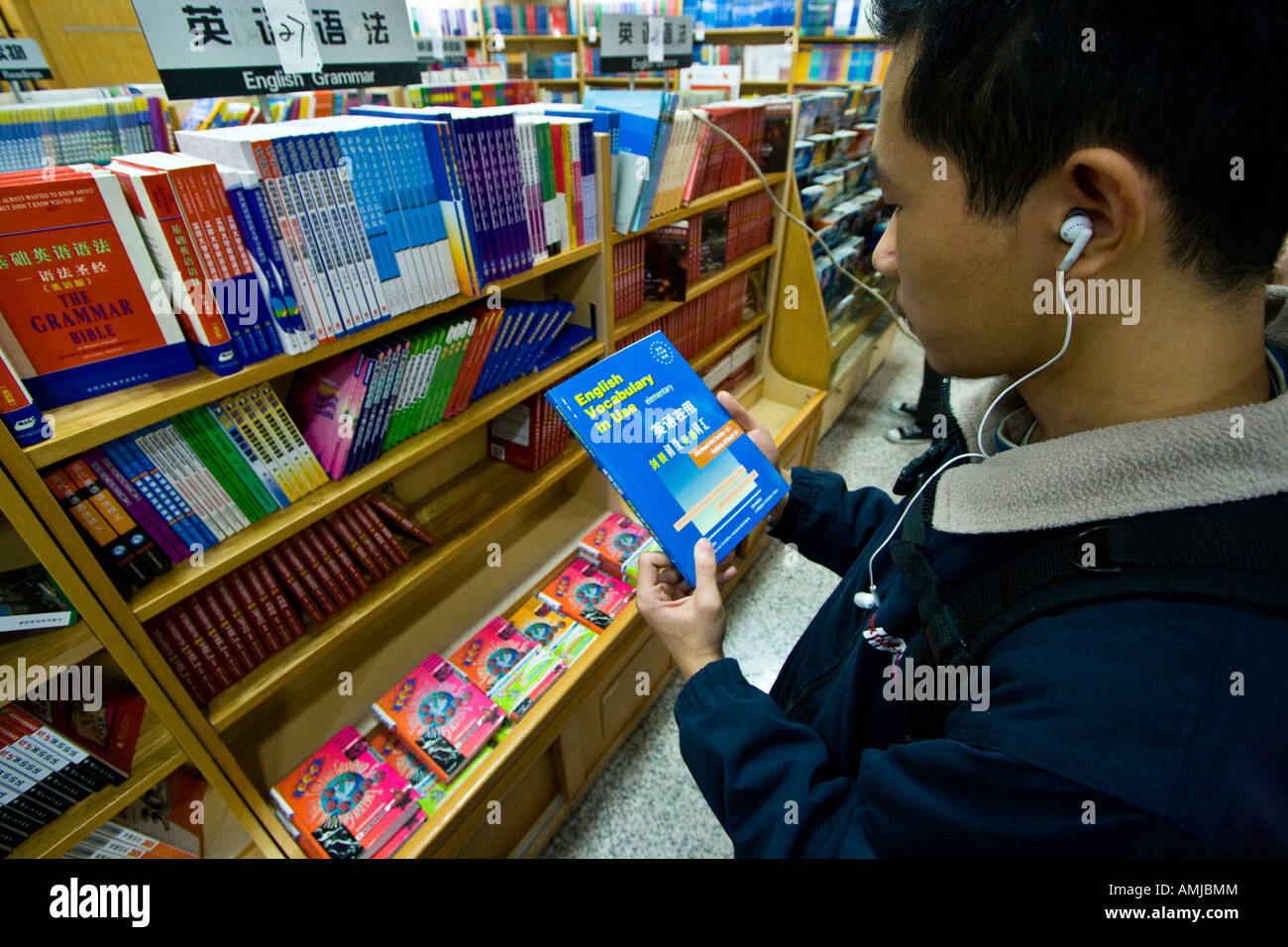 Young Chinese Man with Headphones Reading an English Language Book ...