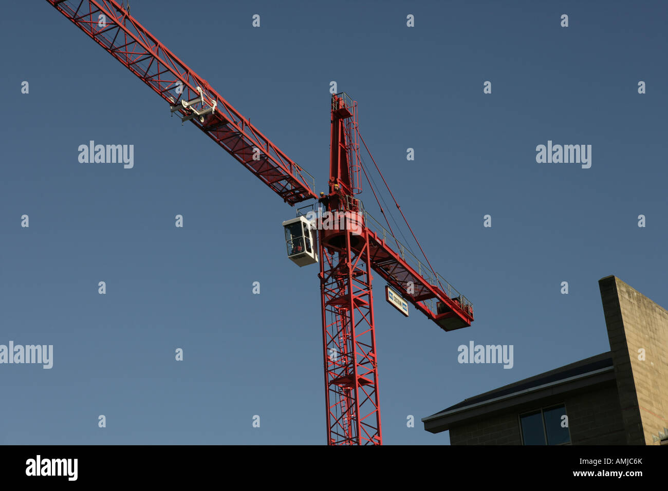 Workmen putting up a tower crane on a builing site to move objects ...