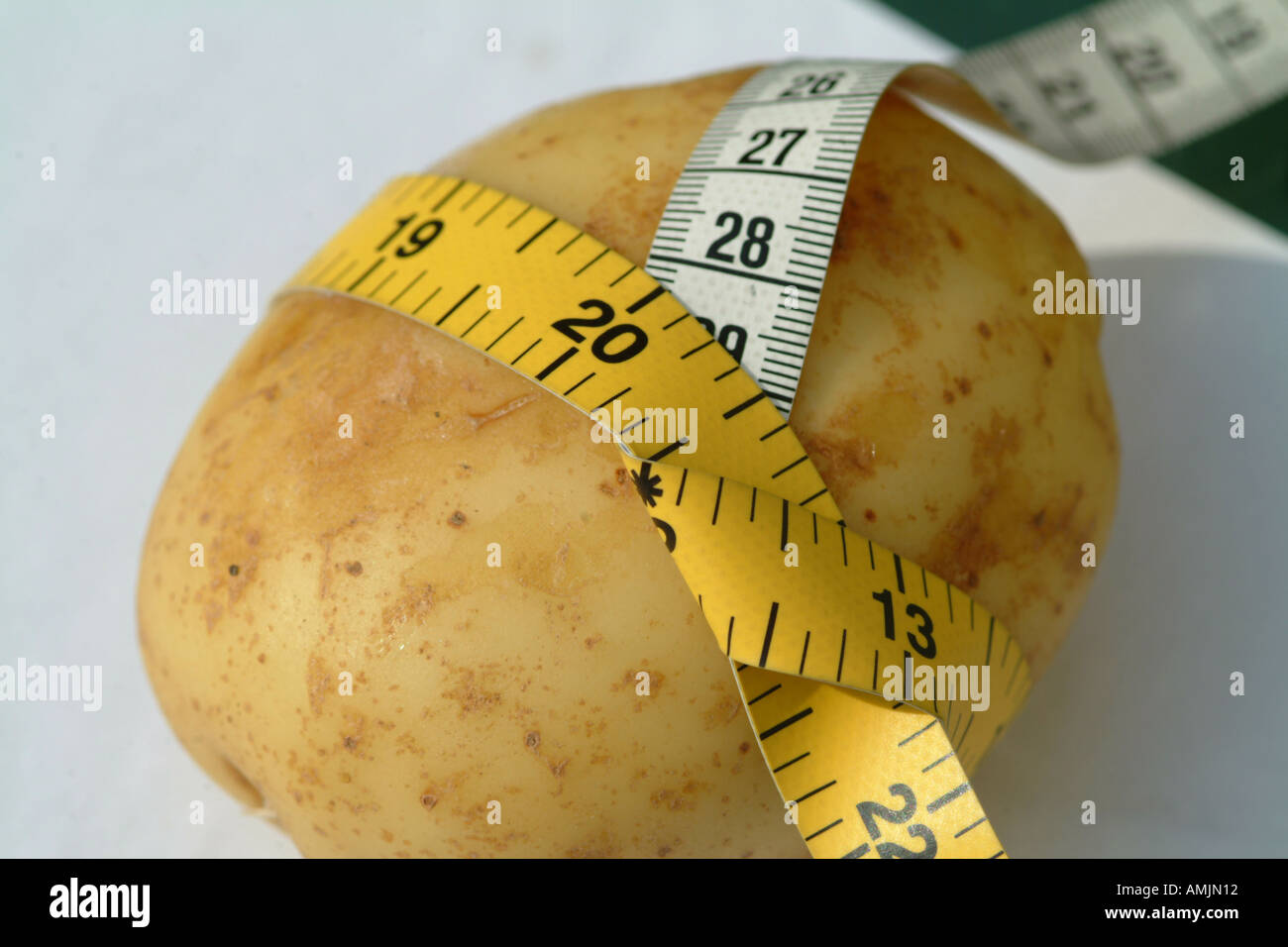 potato with a tape measure around it Stock Photo - Alamy