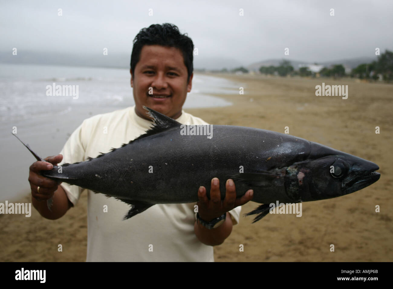 fisherman holding big fish on the beach Stock Photo - Alamy