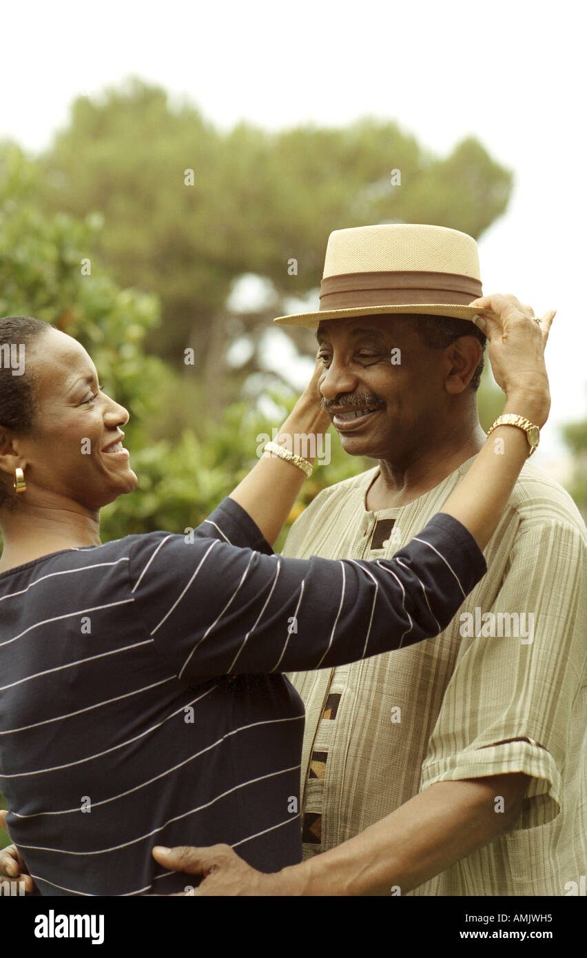 Woman putting hat on man's head Stock Photo - Alamy