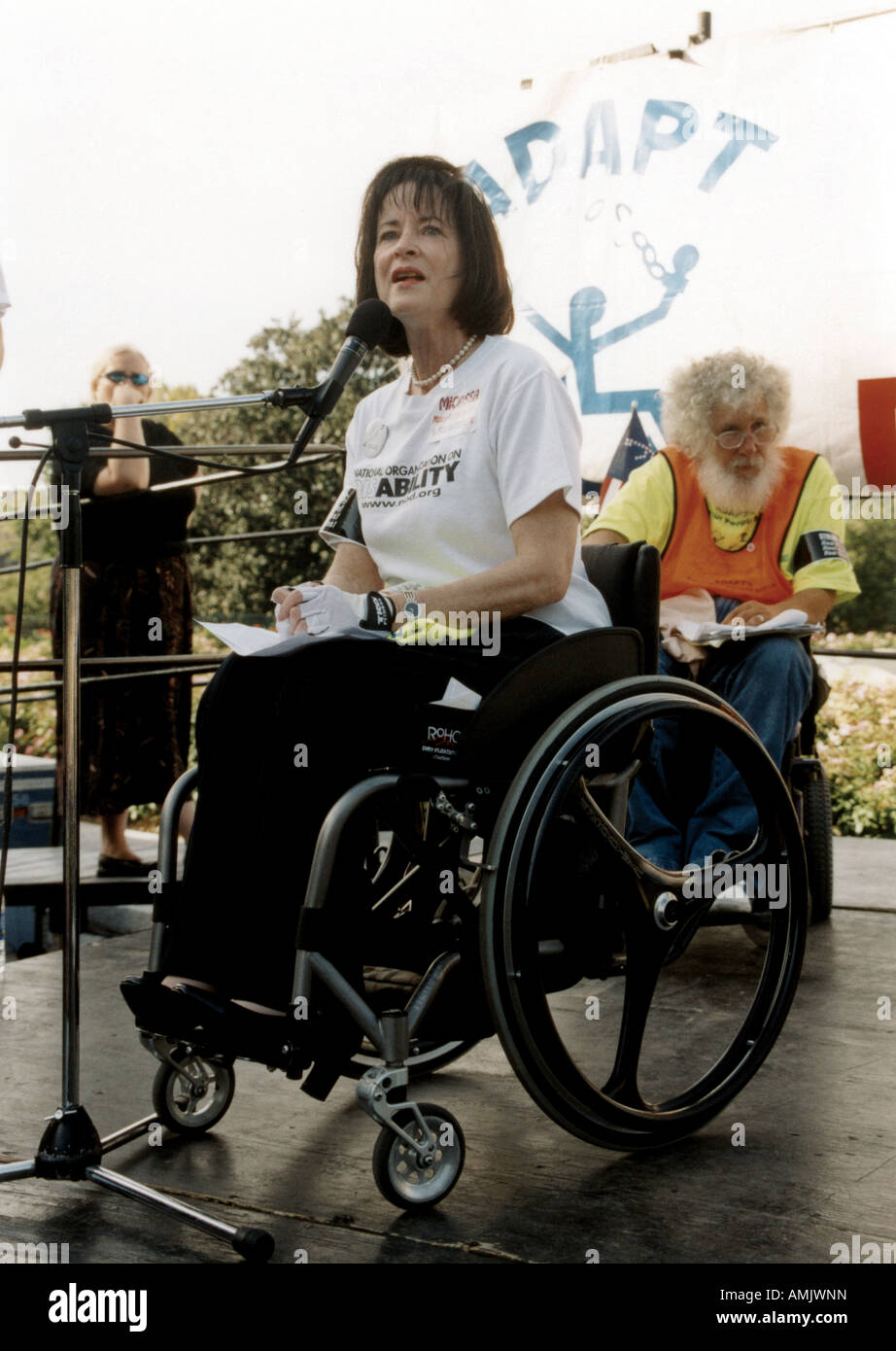 Woman in a wheelchair speaking to a crowd with disabilities at the ...