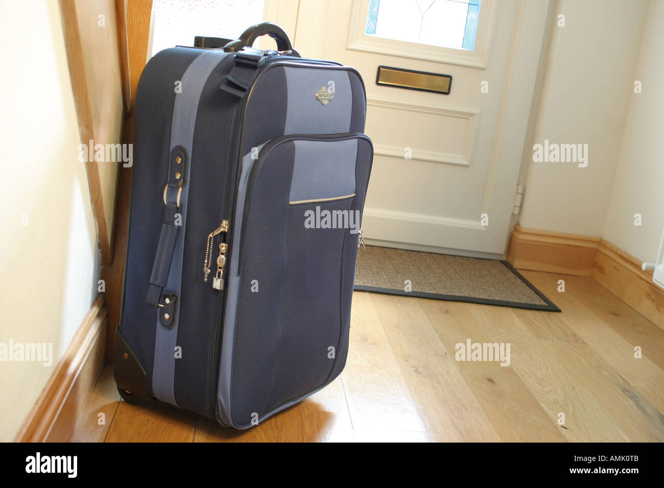 suitcase at a front door Stock Photo - Alamy