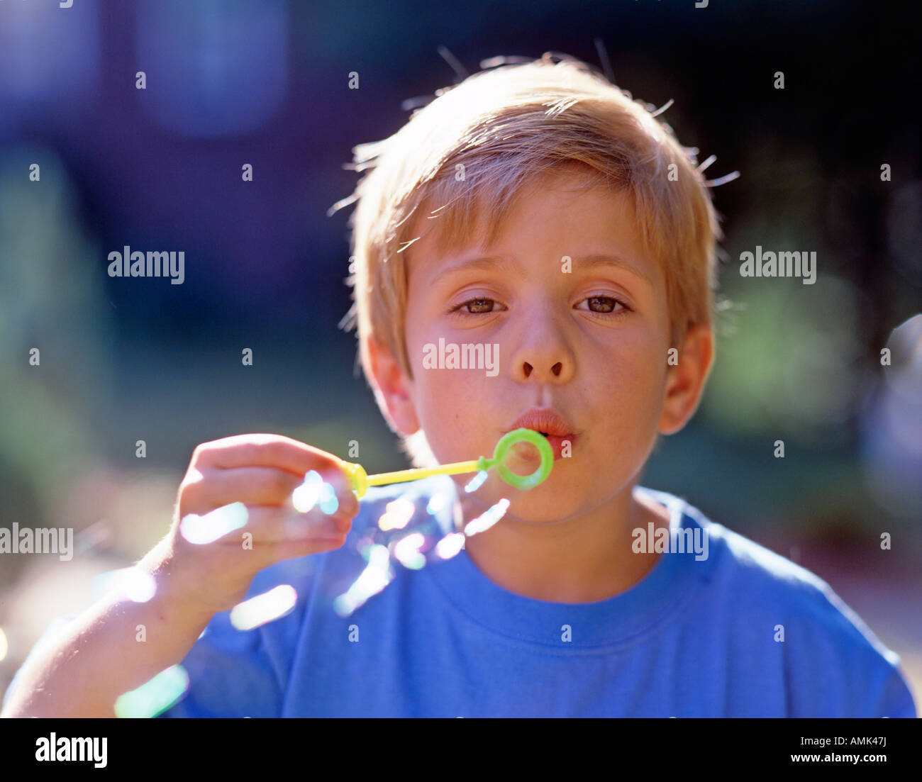 Portrait of a boy blowing bubbles front view Stock Photo - Alamy