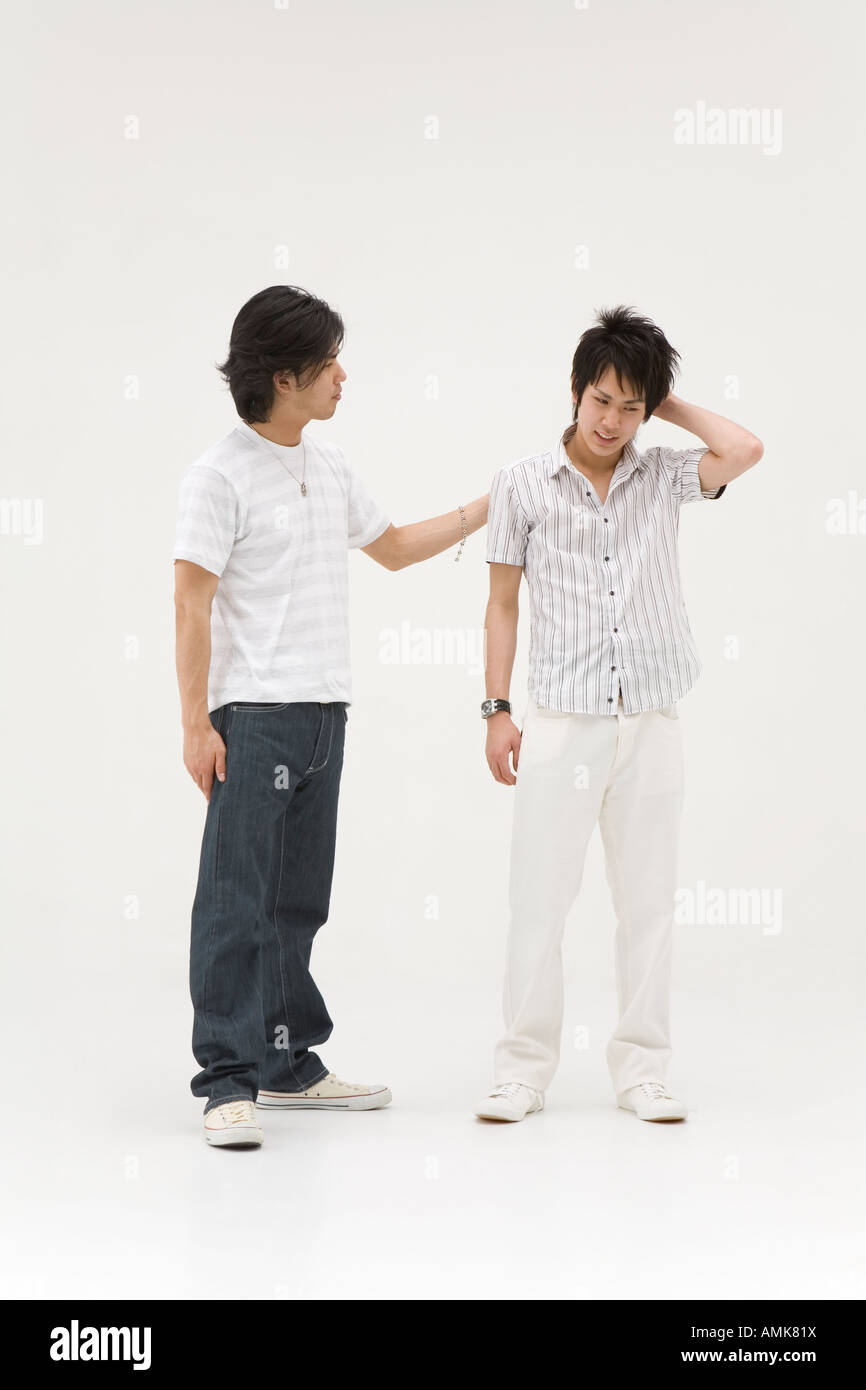 Young man comforting his friend Stock Photo - Alamy